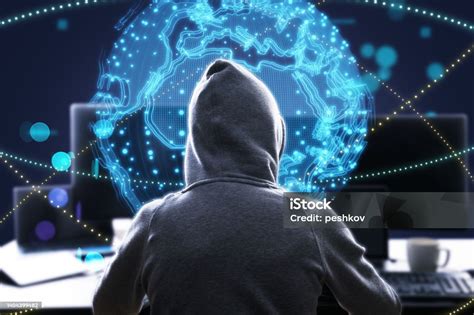 밝은 지구 홀로그램과 노트북을 사용하여 데스크톱에서 해커의 뒷면보기 행성 지구의 홀로그램 투영 흐릿한 추상적 인 어두운 배경에서 깜박이는 에너지 입자 과학 해킹