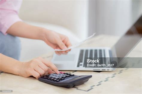 집에서 책상에 계산기로 금융 가구를 계산하는 여성의 클로즈업 손 저축 및 계획 비용 부채 및 대출 세금 및 회계 비즈니스 및