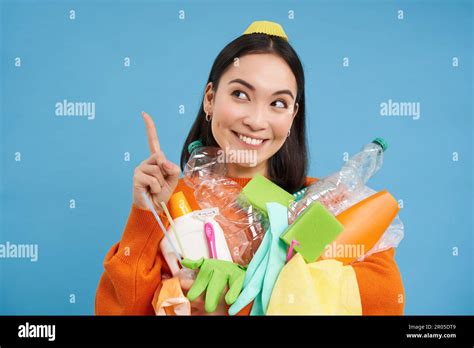 Enthusiastic Asian Woman Holding Plastic Empty Bottles And Garbage For