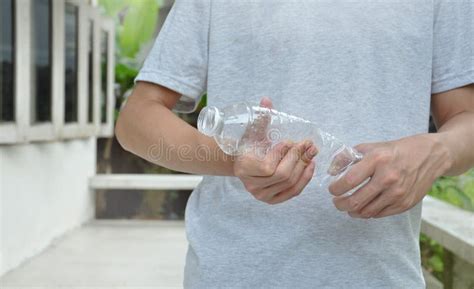 Man Sorting Plastic Bottles In Garbage Disposal Point In Front Of A