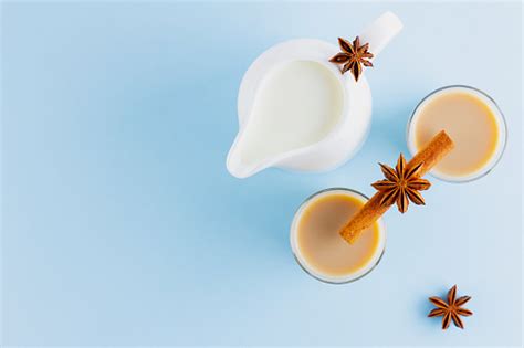 파란색 배경에 우유와 향신료를 곁들인 차 터키 티컵에 마살라 차이 파스텔 배경에 인도 국가 음료와 우유 주전자 공간을 복사합니다 위쪽 보기 0명에 대한 스톡 사진 및 기타