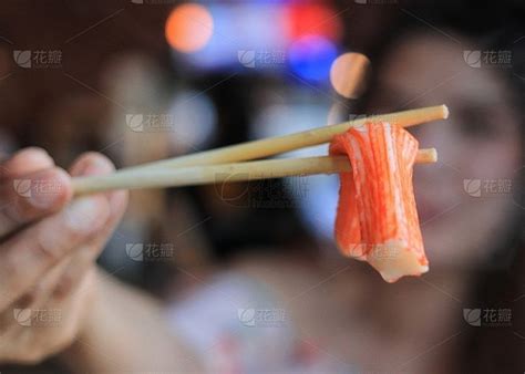 女性用筷子夹住蟹棒
