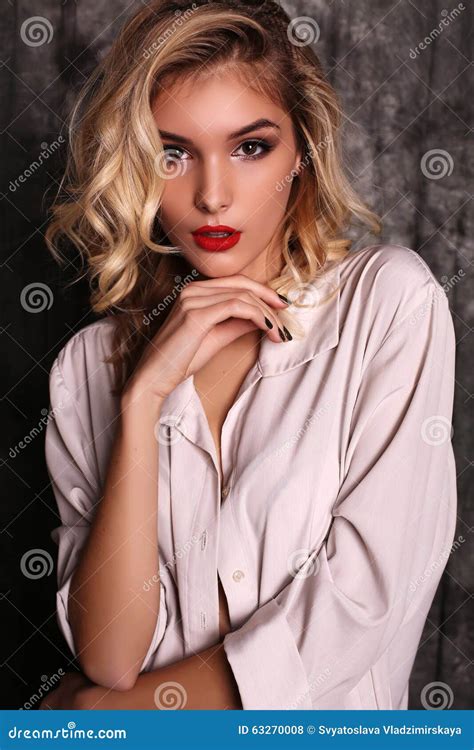 Beautiful Woman With Blond Curly Hair And Evening Makeupwears White
