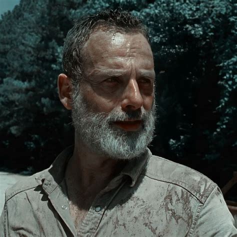 A Man With A White Beard Wearing A Shirt And Looking At The Camera