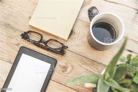 나무 테이블과 녹색 알로에 식물에 책과 안경 옆에 새로운 기술 전자 책의 위에서 여전히 생활보기 기존의 기존 통신 시스템과 비교하여 새로운 기술 무선 장치 0명에 대한 스톡