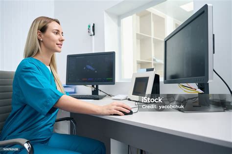파란 옷을 입은 여성이 테이블에 앉아 컴퓨터에서 일합니다 책상에 대한 스톡 사진 및 기타 이미지 책상 컴퓨터 25 29세 Istock
