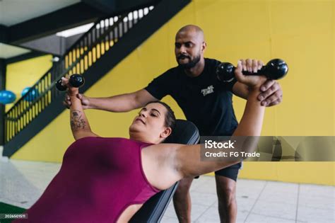 ダンベルとジムでフィットネスインストラクターと一緒に運動する成熟した女性 ベンチプレスのストックフォトや画像を多数ご用意 ベンチプレス
