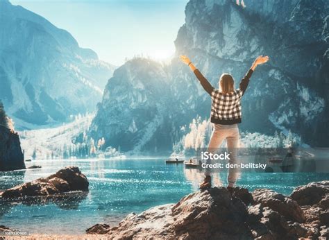 석양 해안의 Braies 호수에 제기를 무기와 돌에 행복 한 젊은 여자 이탈리아 Dolomites에가 여자 산와 프리 반사와 물