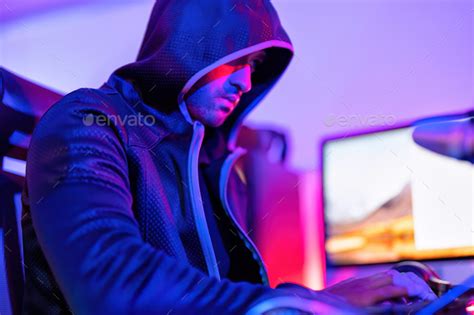 Hacker Wearing Hood Jacket Typing Computer Keyboard To Phishing Steal