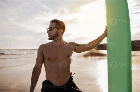 Portrait Of Handsome Young Man Holding Surfboard At The Beach Professional Surfer Guy In