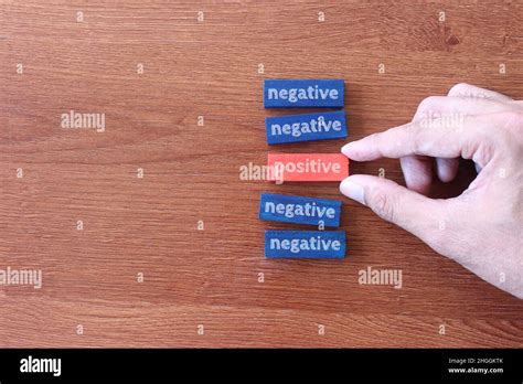 Top View Image Of Hand Pick Wooden Cube With Text POSITIVE Over