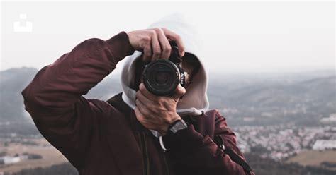 Foto Hombre Con Chaqueta Negra Sosteniendo Una Cámara Dslr Negra