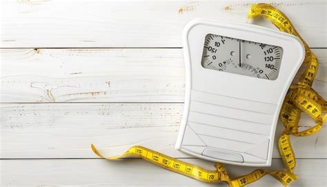 Weigh Scales Tied With Measuring Tape On White Wooden Table Top View