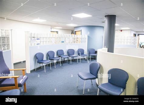 Empty Waiting Room With Blue Chairs And Wall Mounted Bulletin Boards Of