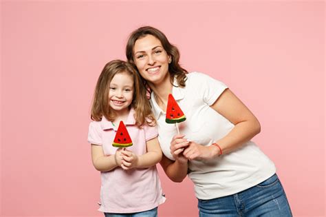 가벼운 옷에 여자는 귀여운 아이 아기 소녀와 재미가 있다 어머니 작은 아이 딸 파스텔 분홍색 벽 배경 스튜디오 초상화에 고립 어머니의 날 사랑 가족 부모가 어린 시절의 개념