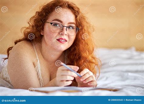 Pretty Half Naked Redhead Woman Make Notes Lying On Bed Stock Photo
