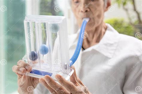 Senior Patient Using Incentive Spirometer Tool To Help The Lung