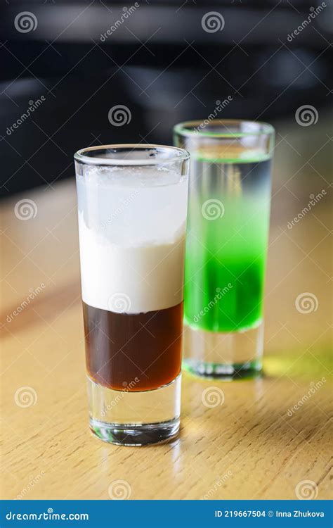 Two Kinds Of Alcoholic Drinks In Shot Glasses Obn A Wooden Table Over