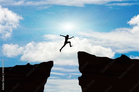 Man Jump Through The Gap Between Hill Man Jumping Over Cliff On Sunset