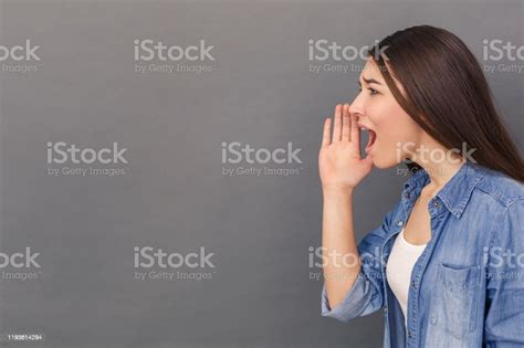 텍스트 또는 제품의 공간을 복사합니다 젊은 여자 에 데님 셔츠 서 스튜디오 고립 에 회색 외침 큰 소리로 갈색 머리에 대한 스톡 사진 및 기타 이미지 Istock