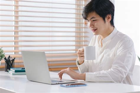 젊은 사업가가 홈 오피스에서 노트북 컴퓨터로 작업하는 모습을 보여줍니다 이미지는 재택 근무의 개념을 나타냅니다 30 34세에