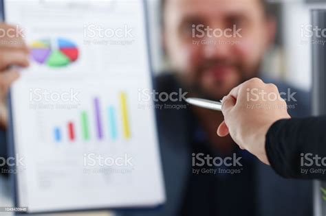 그의 팔에서 사업 보류 바인더 토론 그의 파트너와 함께 그들의 미래 프로젝트 가리키기에 대한 스톡 사진 및 기타 이미지
