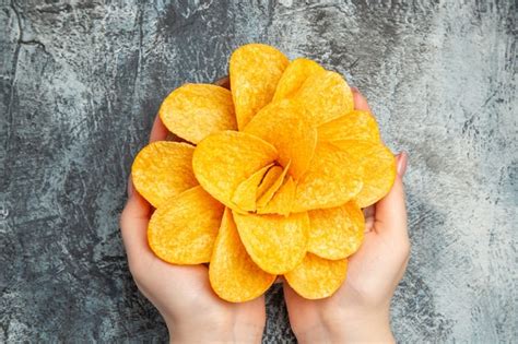 Руки держат домашние вкусные хрустящие чипсы в коричневой миске на ...