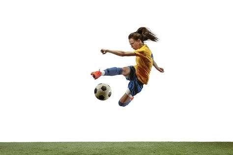 경기장에서 공을 차는 여자 축구 선수 프리미엄 사진