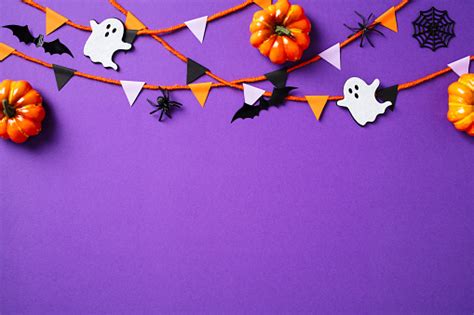 해피 할로윈 휴일 개념입니다 보라색 배경에 종이 화환 유령 호박 거미 박쥐와 함께 평평하게 놓으십시오 할로윈 인사말 카드 디자인