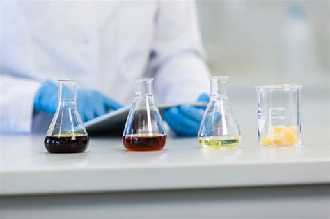 실험실 책상 위에 흰색 태블릿에 입력 의료 장갑손 대마 씨앗 마리화나 꽃 봉오리 Cbd 및 Cbda 오일이 테이블에 있습니다