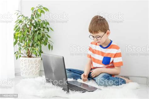 안경과 줄무늬 티셔츠를 입은 소년이 집에 앉아 컴퓨터 게임을하고 있습니다 현대 기술과 어린이 6 7 살에 대한 스톡 사진 및 기타 이미지 Istock