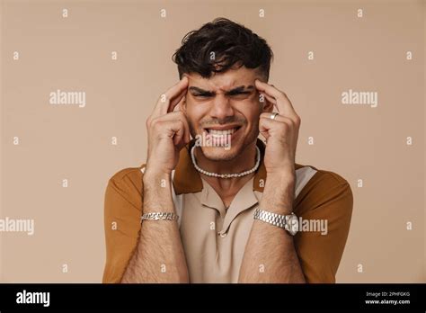 Young Handsome Stylish Tense Man With Closed Eyes And Clenched Teeth Touching His Temples
