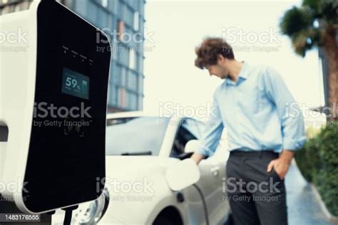 흐릿한 남자 배경이 있는 충전소에서 초점 Ev 자동차의 진보적인 개념 교통수단에 대한 스톡 사진 및 기타 이미지 교통수단