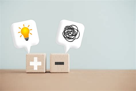 플러스와 마이너스가 있는 두 개의 나무 큐브 블록 생각의 얽힘과 창의적 솔루션 문제 해결 아이디어 지능적이고 긍정적인 사고 개념을 위해 흰색 말풍선에 전구를 밝게 합니다 0