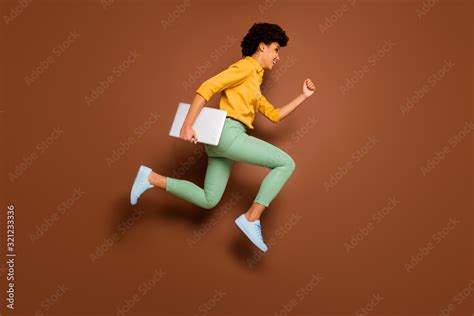 Full Length Profile Photo Of Funny Dark Skin Lady Jumping High Holding