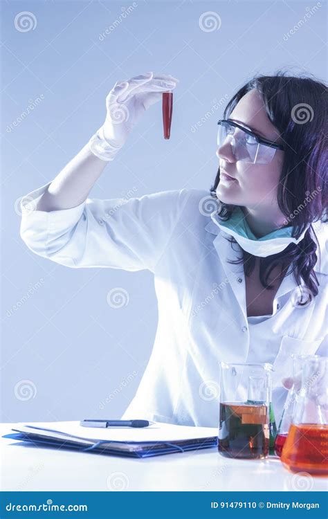 Female Laboratory Worker Looking At Flask Filled With Liquid Chemical During Experimen Stock
