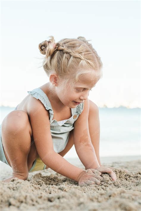 Premium Photo Cute Girl Playing With Sand On Beach