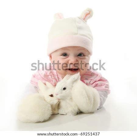 Portrait Of An Adorable Baby Girl Wearing A Bunny Rabbit Costume And Petting Two Baby Bunnies