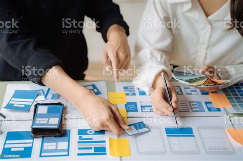 Ui 디자이너가 사무실에서 고객 브리프와 색상 코드를 사용한 모바일 앱 인터페이스 와이어프레임 디자인에 대해 브레인스토밍합니다 계획에 대한 스톡 사진 및 기타 이미지