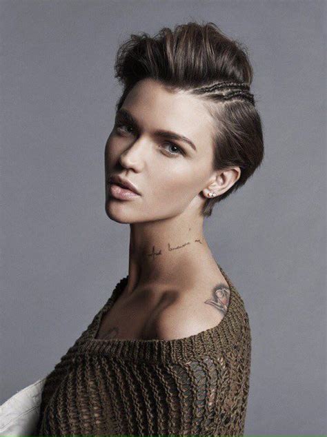 A Woman With Tattoos On Her Neck And Shoulder Is Posing For The Camera