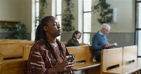 캐주얼 드레스를 입은 젊은 기독교 흑인 여성이 교회 벤치에 앉아 주님께 기도하는 동안 눈을 감고 있다 사진 Unsplash의 사람 이미지