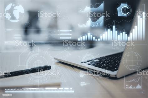 나무 책상 위에 있는 노트북을 펜과 비즈니스 차트가 흐릿한 배경에 홀로그램으로 덮는다 군사 통제 세계 경제 및 재정 가상 다이어그램 이중 노출 Brand Name