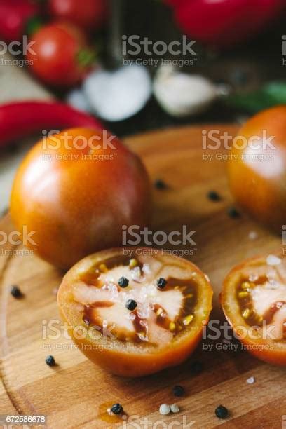 야채와 향신료로 둘러싸인 나무 판에 구마토 토마토의 반쪽 0명에 대한 스톡 사진 및 기타 이미지 0명 검은색 날것