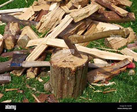 A Lumberjack Axe In A Chopping Block With Split Firewood Around It