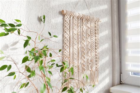 수제 마크라임 흰색 벽에 매달려있는 나무 막대기가있는 100 면화 벽 장식 Macrame 꼰 끈과 면화 실 여성 취미 Eco