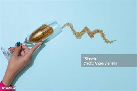파란색 종이 배경에 그려진 황금 요소와 샴페인 피리를 들고 여성 손 크리스마스 축하 개념에 대한 스톡 사진 및 기타 이미지