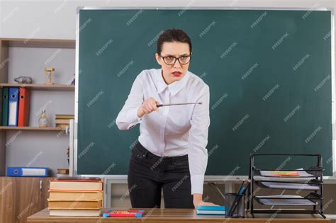 Free Photo Young Woman Teacher Wearing Glasses Holding Pointer While