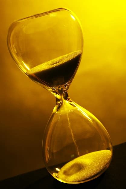 Premium Photo Hourglass On Dark Yellow Background