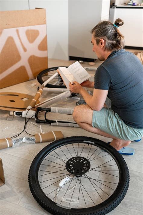 A Man Is Inside Working On Assembling Bike Handlebars As Part Of His