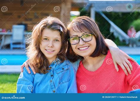 Portrait Of Happy Mom And Teenage Daughter Looking At Camera Stock